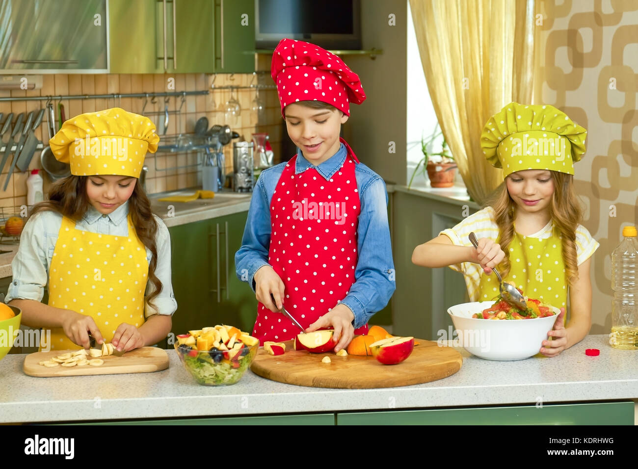 Three kids cooking Stock Photo - Alamy