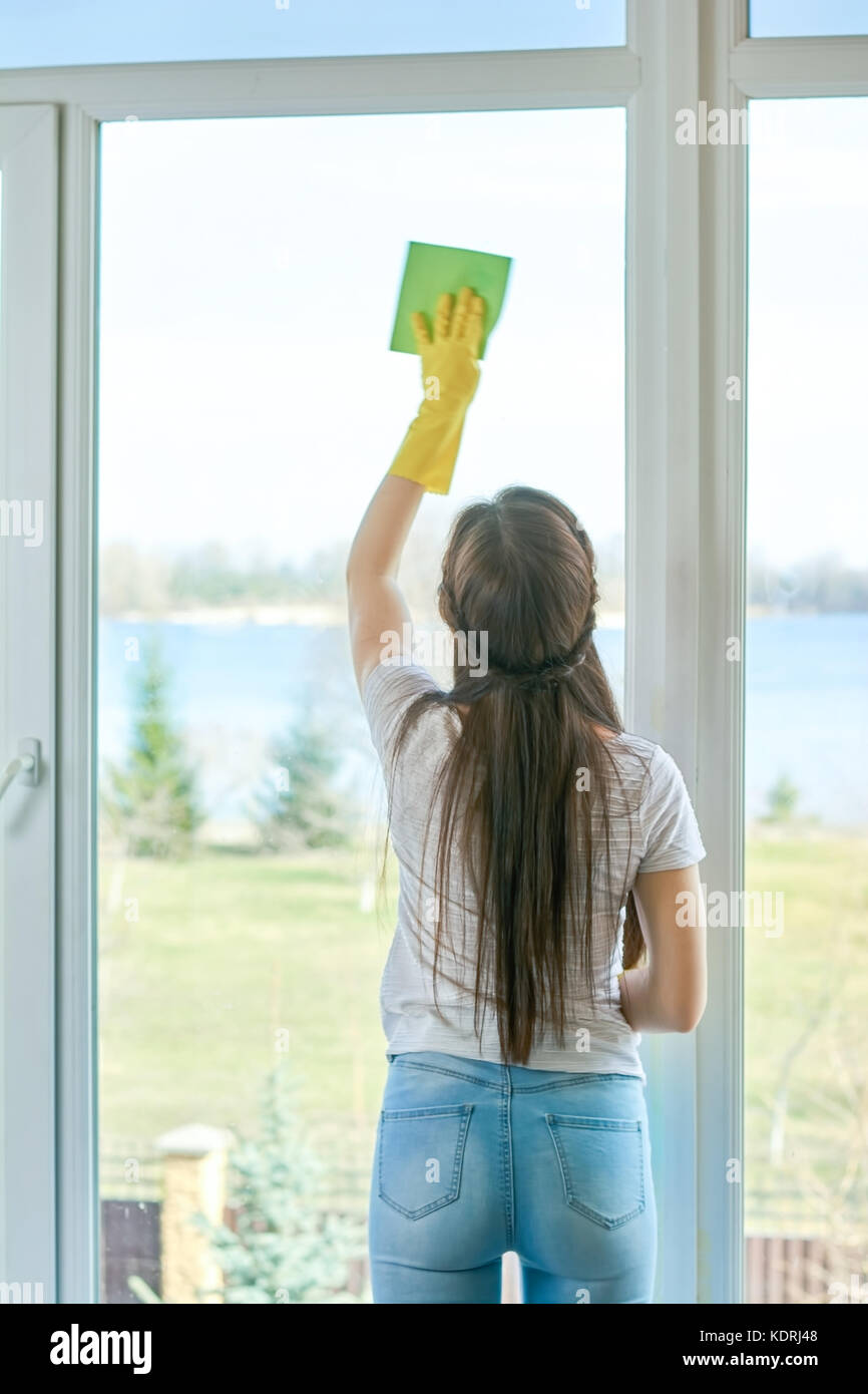 Girl with rag wiping window Stock Photo - Alamy