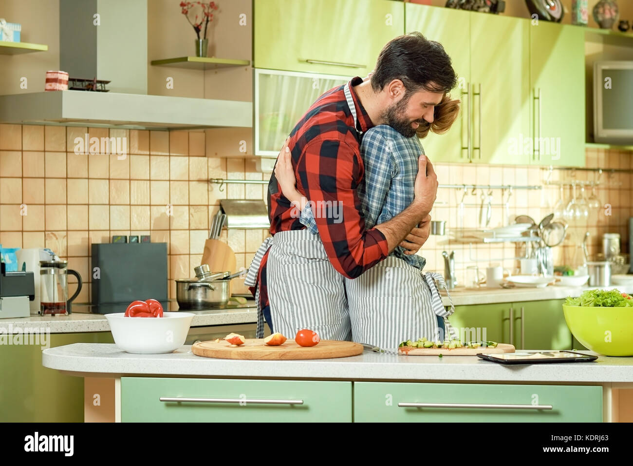 Couple hugging in the kitchen Stock Photo - Alamy