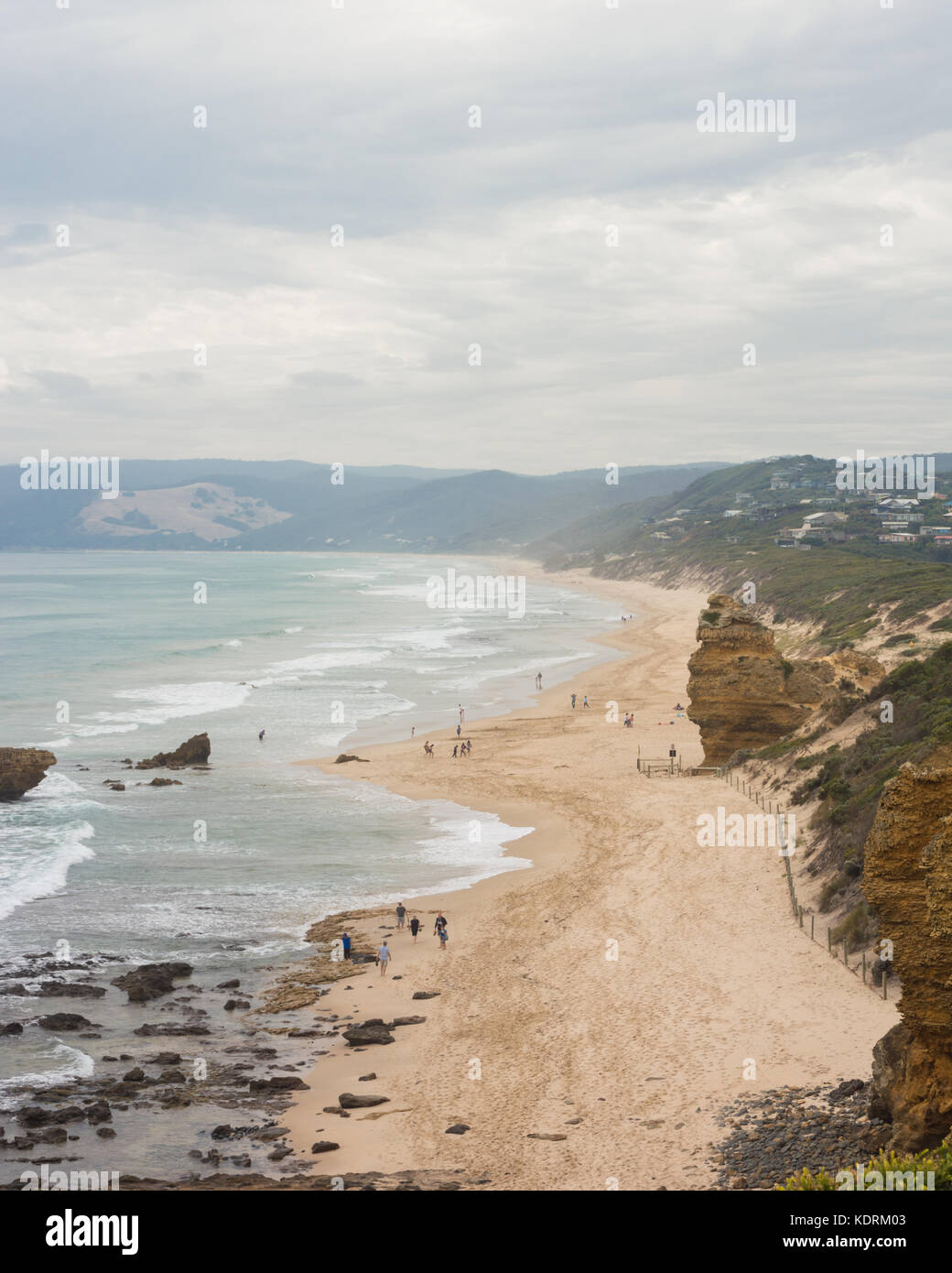 Aerial view looking down a long sandy beach with tall cliffs and gentle ...