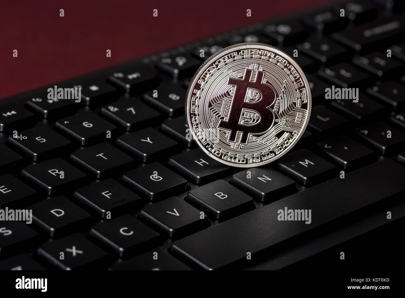 Silver single bitcoin shown at th eletter B on a computer keyboard ...