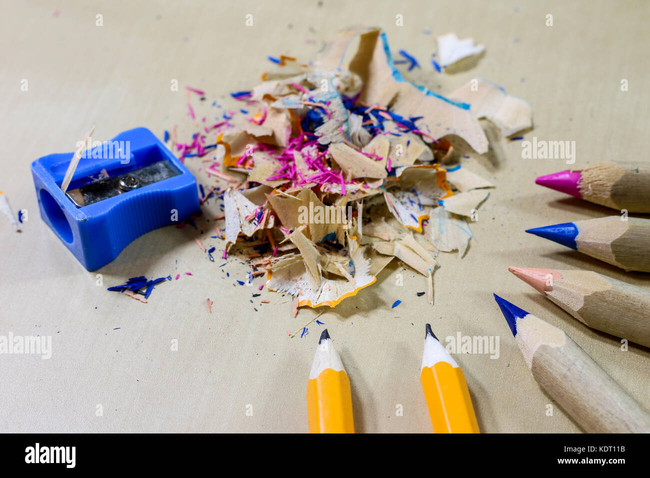 crayons and pencil sharpener on a wooden office table. Crayons with ...