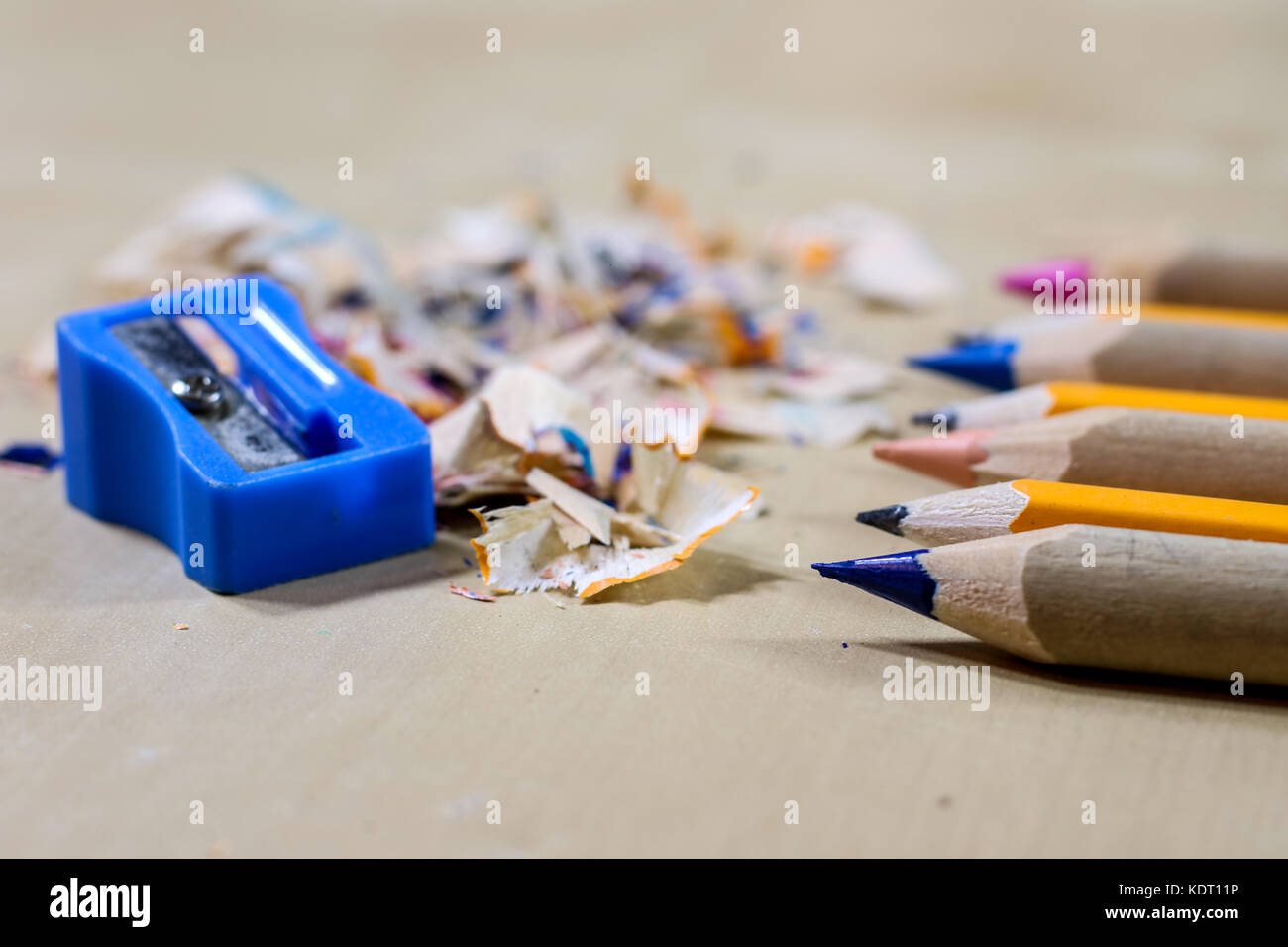 crayons and pencil sharpener on a wooden office table. Crayons with ...