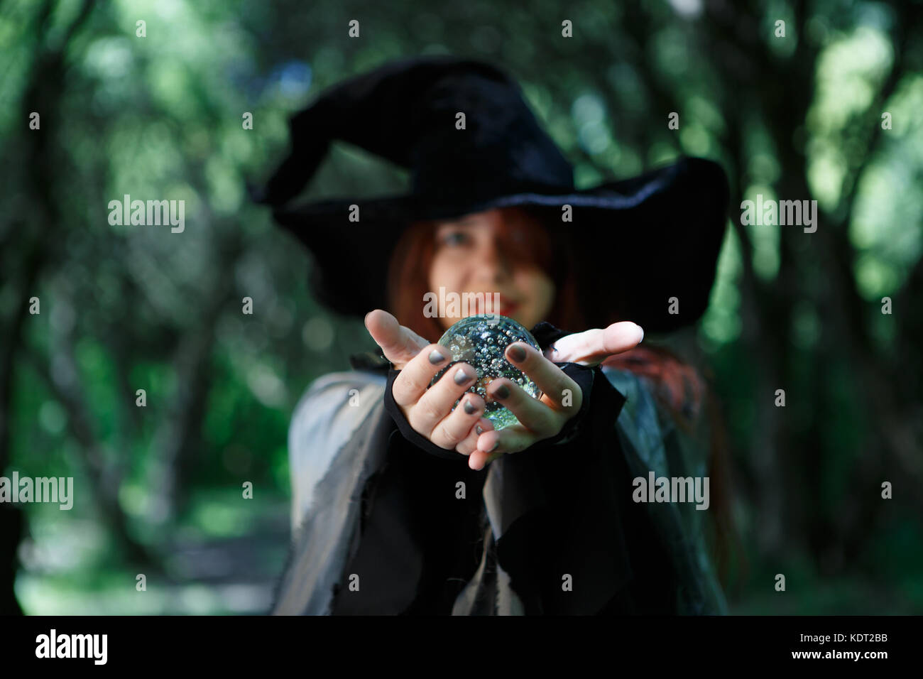 Witch holding magic ball in palms Stock Photo - Alamy