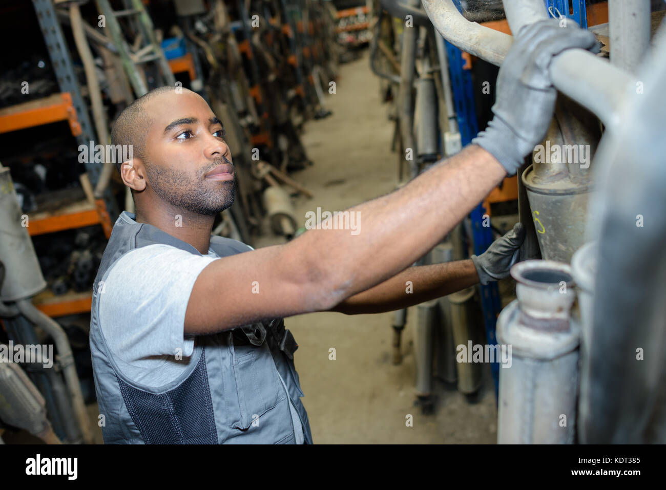 Man selecting used exhaust pipe Stock Photo - Alamy