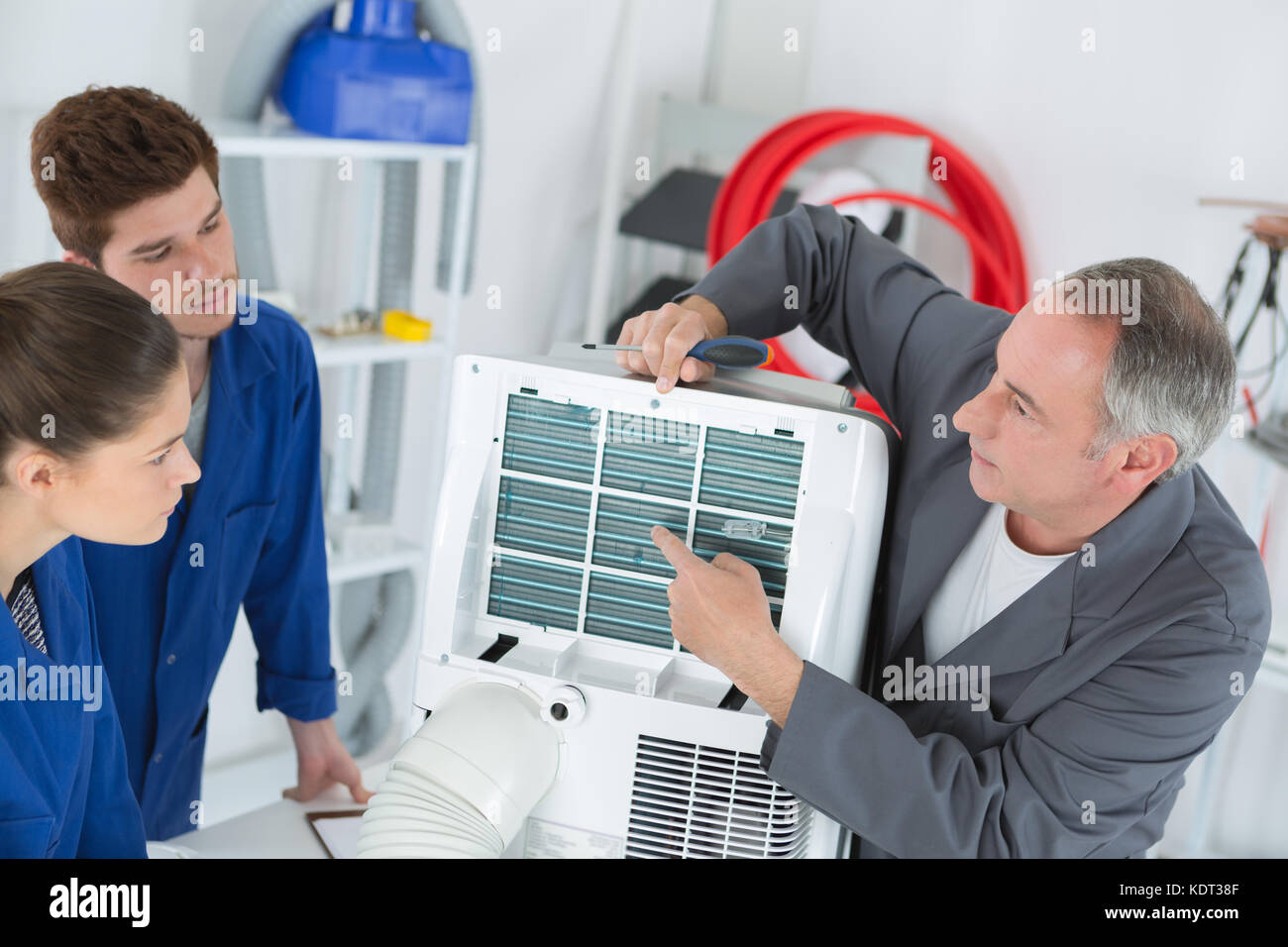 young apprentices repairing air conditioner at class Stock Photo - Alamy