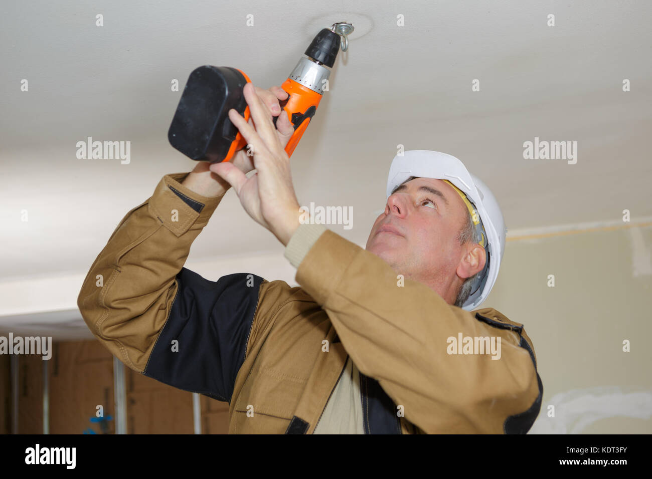 man drilling ceiling Stock Photo - Alamy