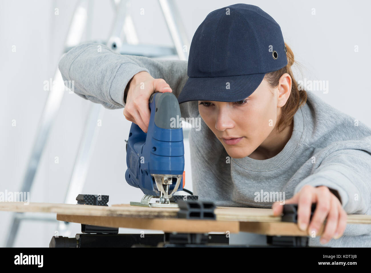 beautiful female carpenter cutting wood in a workshop Stock Photo - Alamy