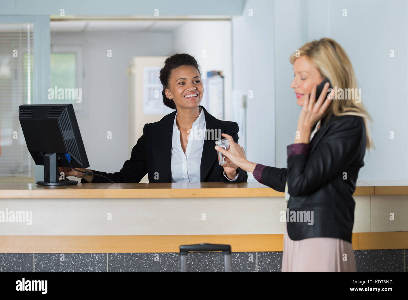 Friendly hotel receptionist handing over hi-res stock photography and ...