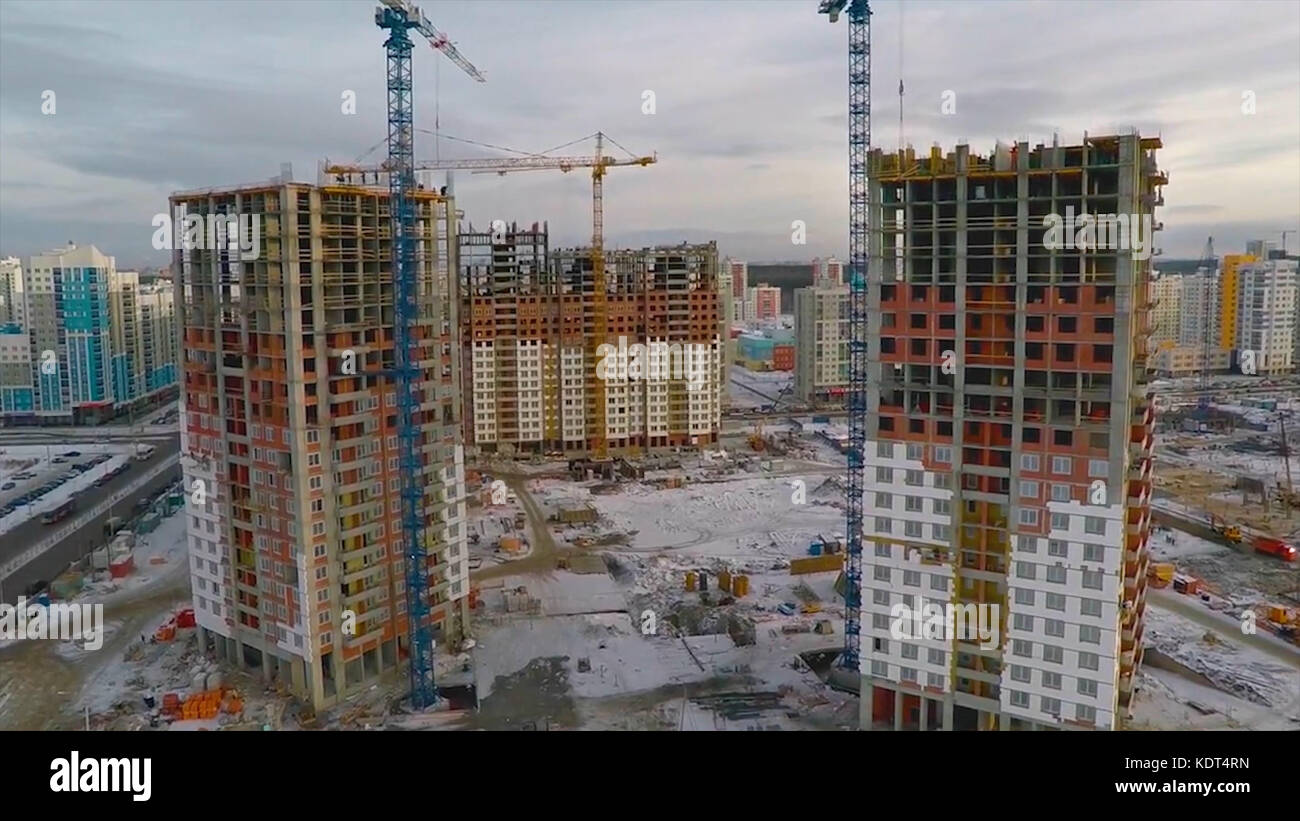Under construction high-rise building with yellow construction crane in ...