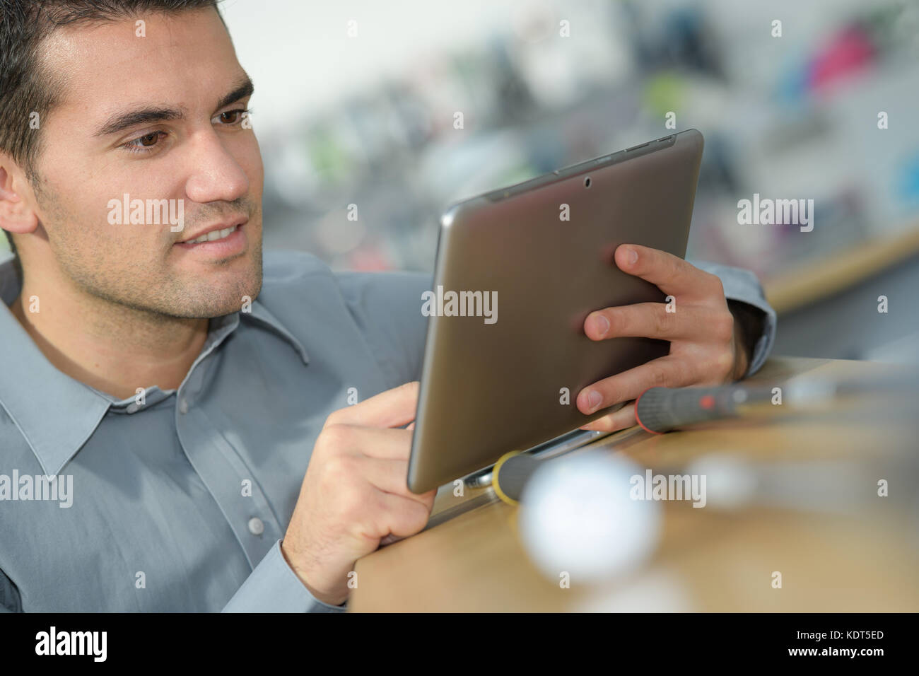 young man watching tablet and smiling Stock Photo - Alamy