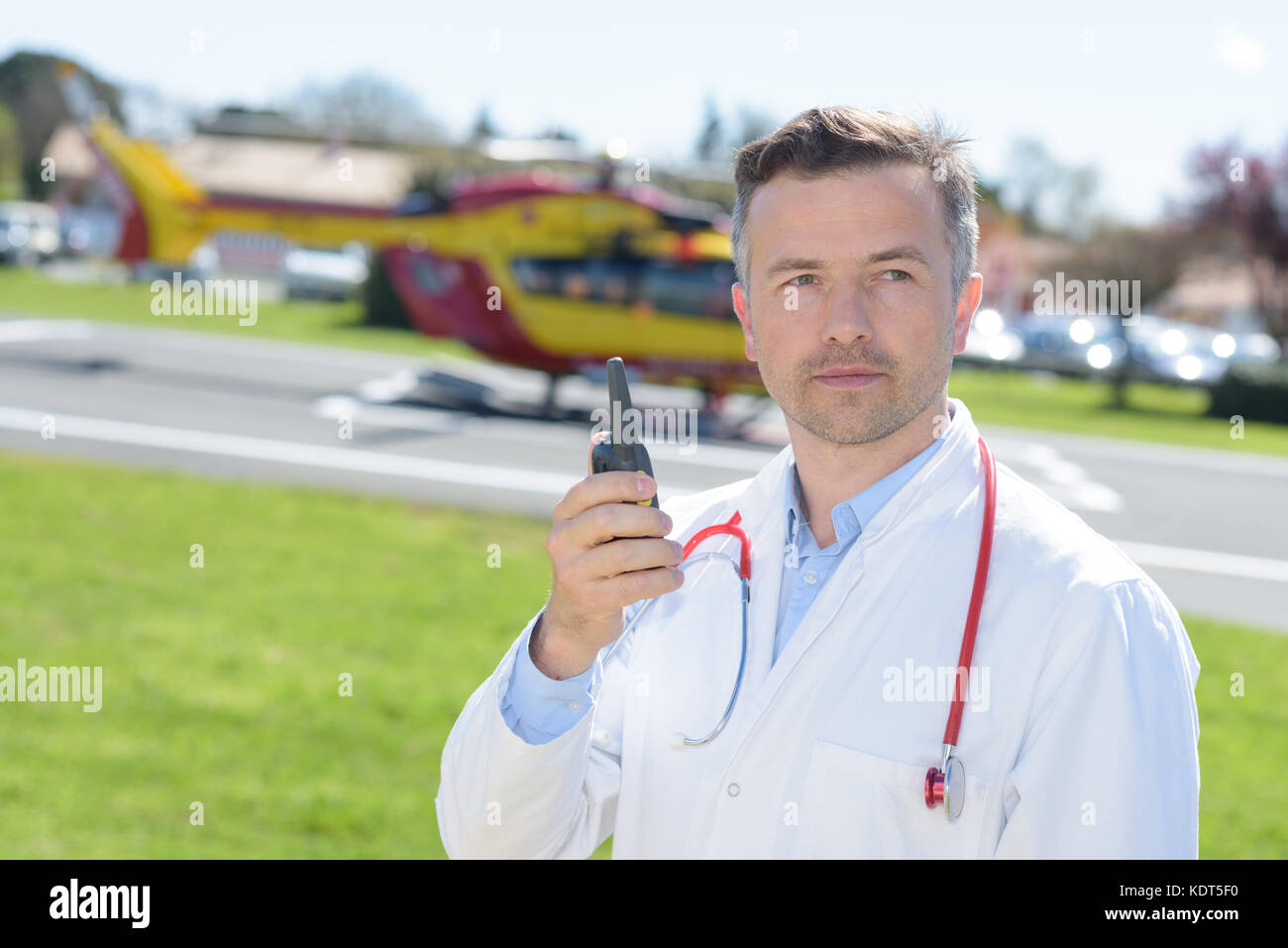 mature male doctor communicating with rescue helicopter Stock Photo - Alamy