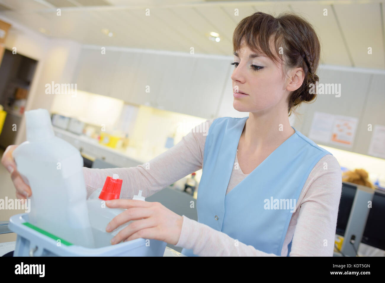 Lady putting products into container Stock Photo - Alamy