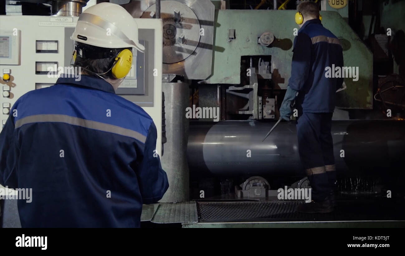 Two workers in production plant as team discussing, industrial scene in ...