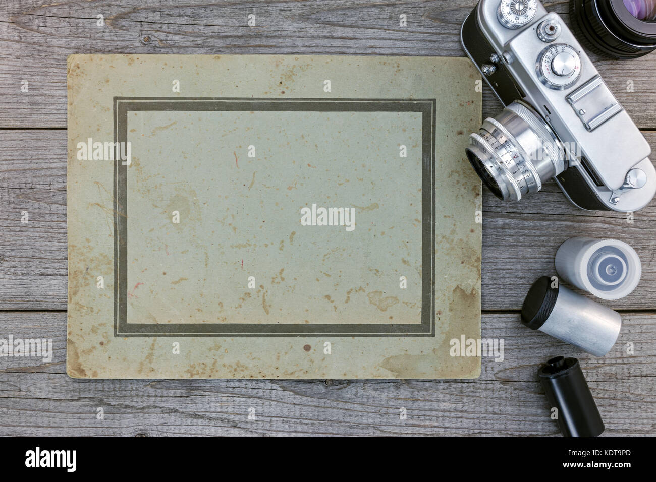 retro cameras, lenses, negative film and old paper on wooden surface ...