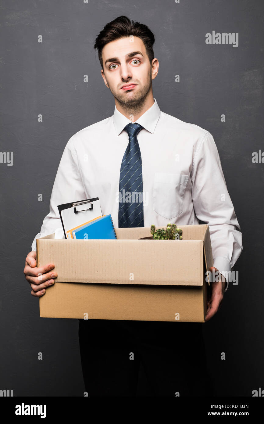 Getting fired. Side view of handsome businessman in formal wear holding ...