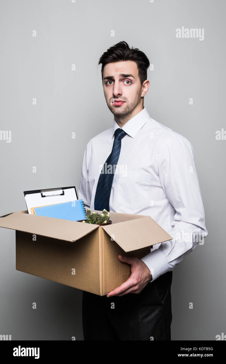 Getting fired. Handsome businessman in suit in office with the box with ...