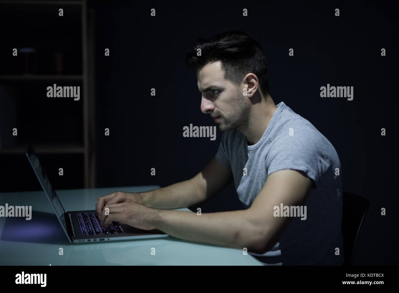 Male programmer working on desktop computer at white desk in office ...