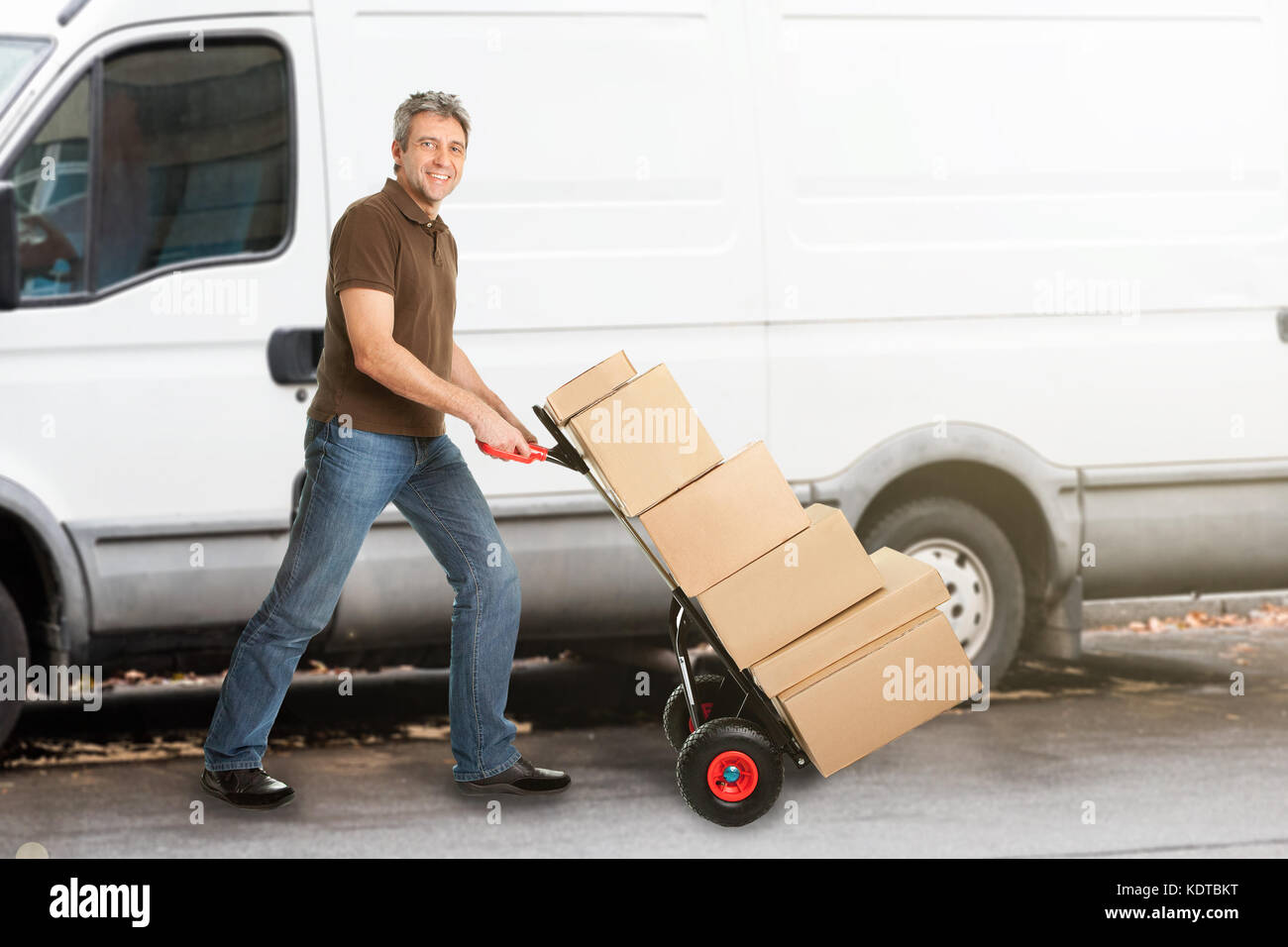 Delivery man pushing trolley parcels hi-res stock photography and ...