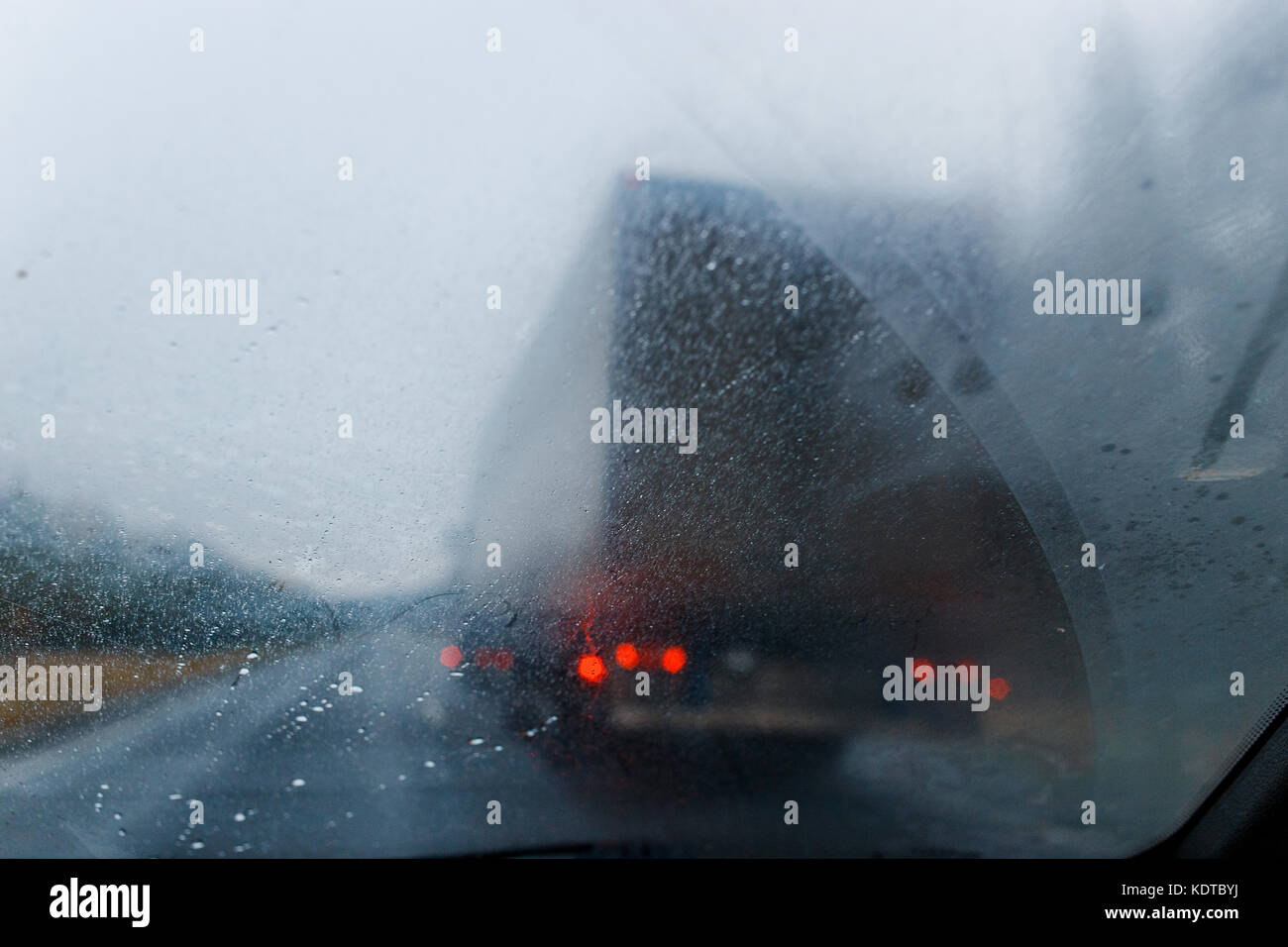 Rain drops on windscreen and blurred truck in forest road. Overtaking ...