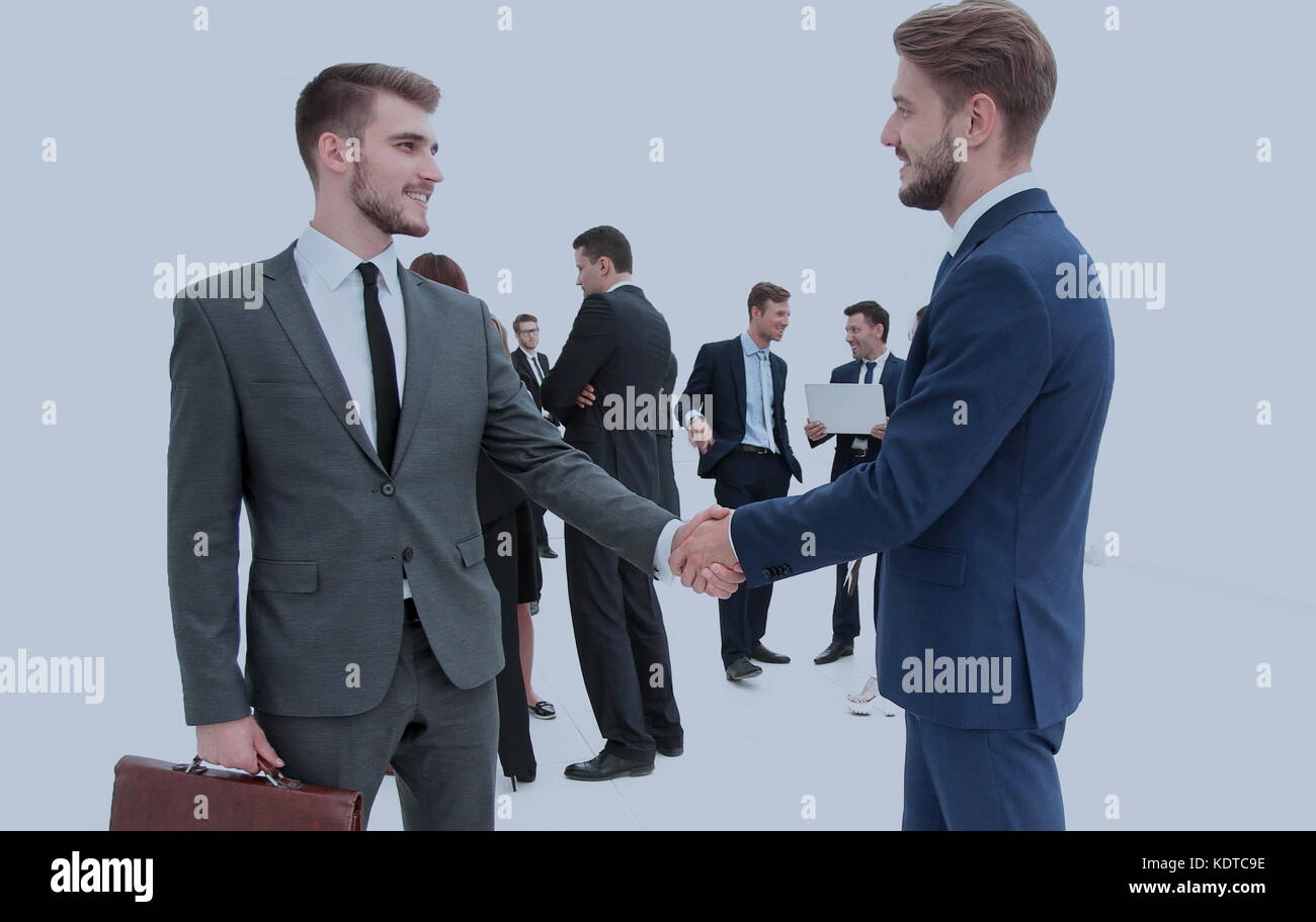 Two businessmen making agreement, their colleagues standing near Stock ...