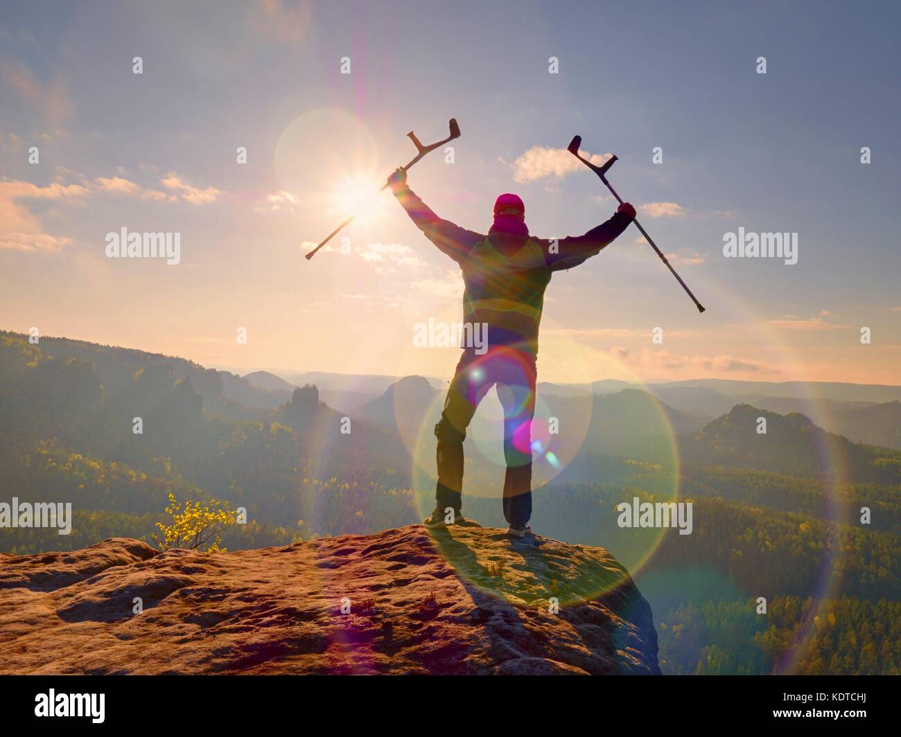 Tourist with forearm crutch above head on trail. Hurt hiker achieved ...