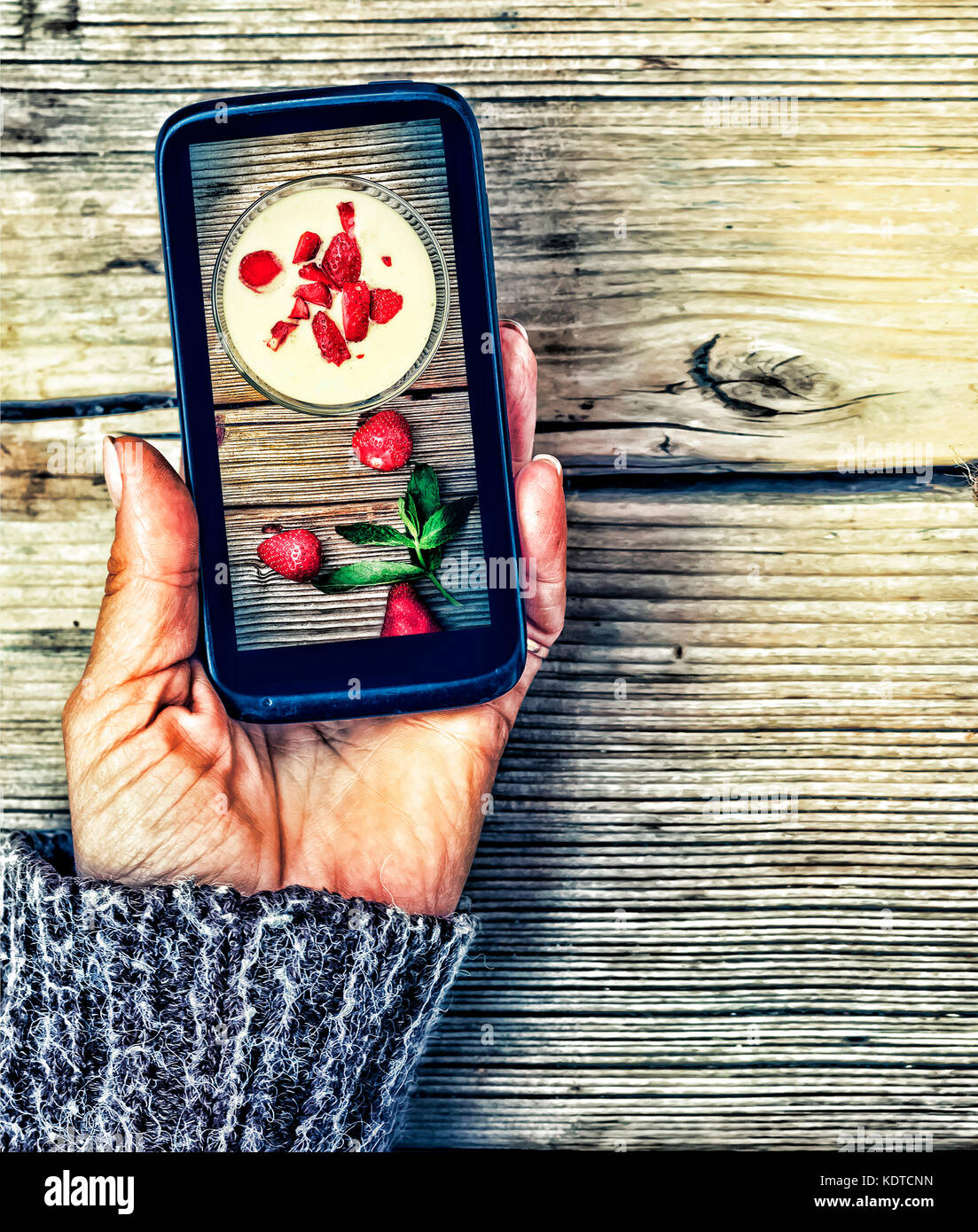 Smartphone in a female hand. display image of strawberry milkshake ...