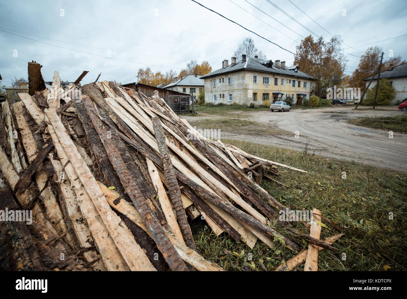Typical russian autumn landscape with firewood near ragged houses ...