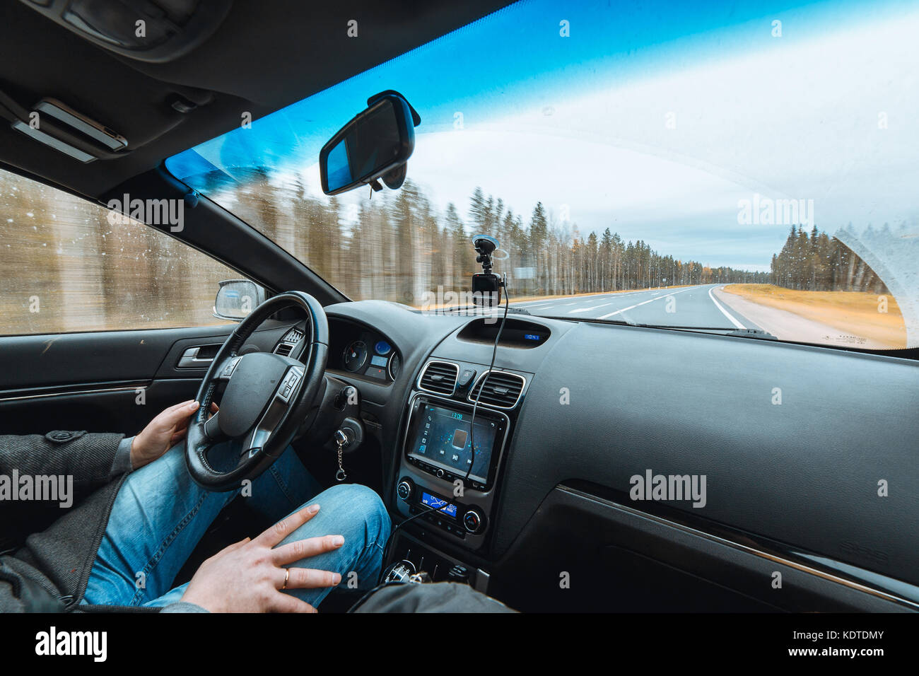 View of the empty road and forest through the windshield of the car ...
