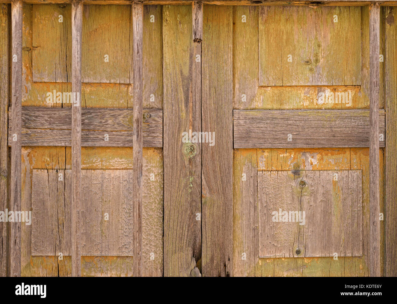 Old Paneled Wooden Door,faded and weathered, in need of maintenance, wooden bars,background with ...