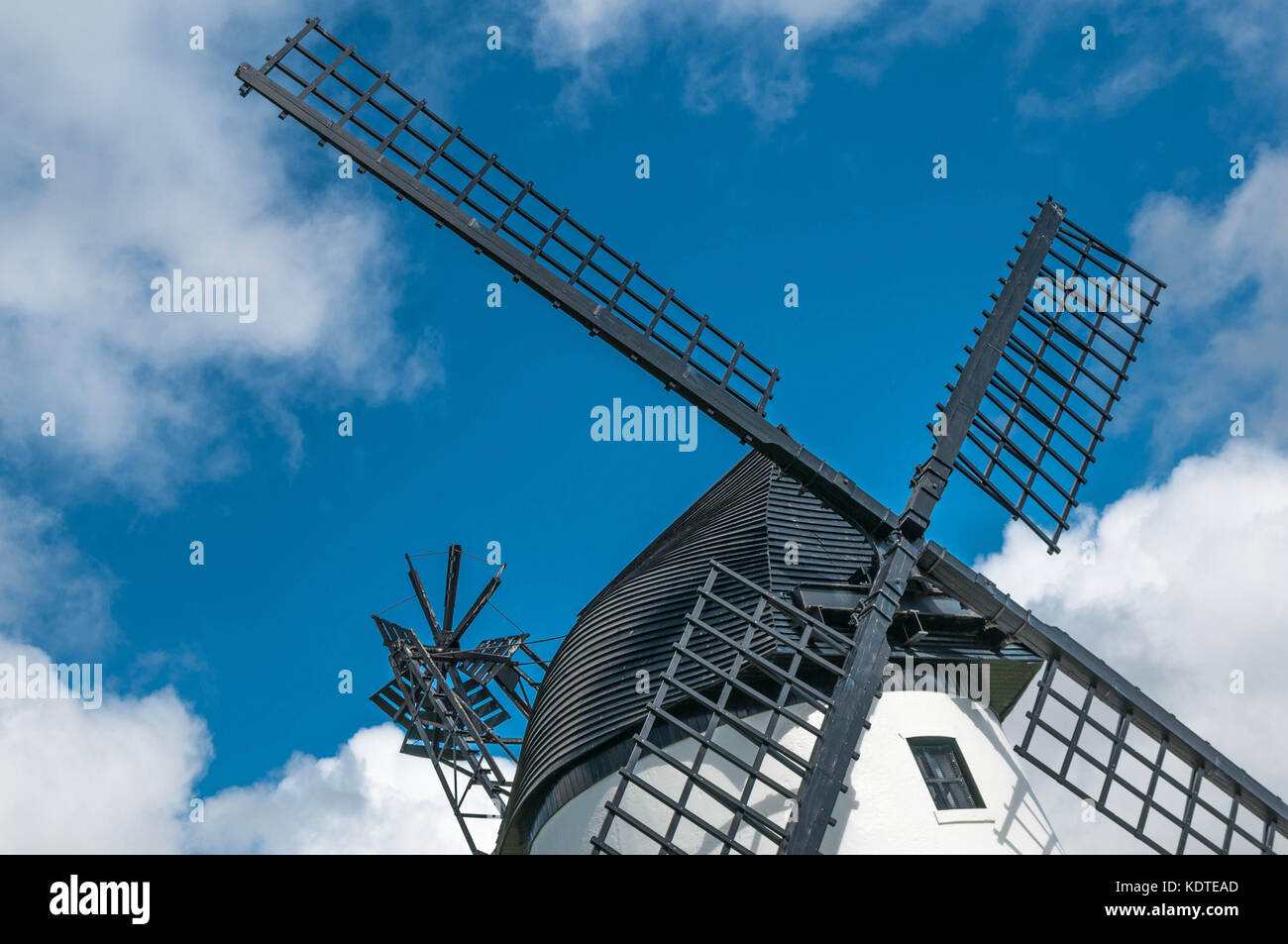 Windmill, with black sails ,wooden slatted roof against blue sky with ...