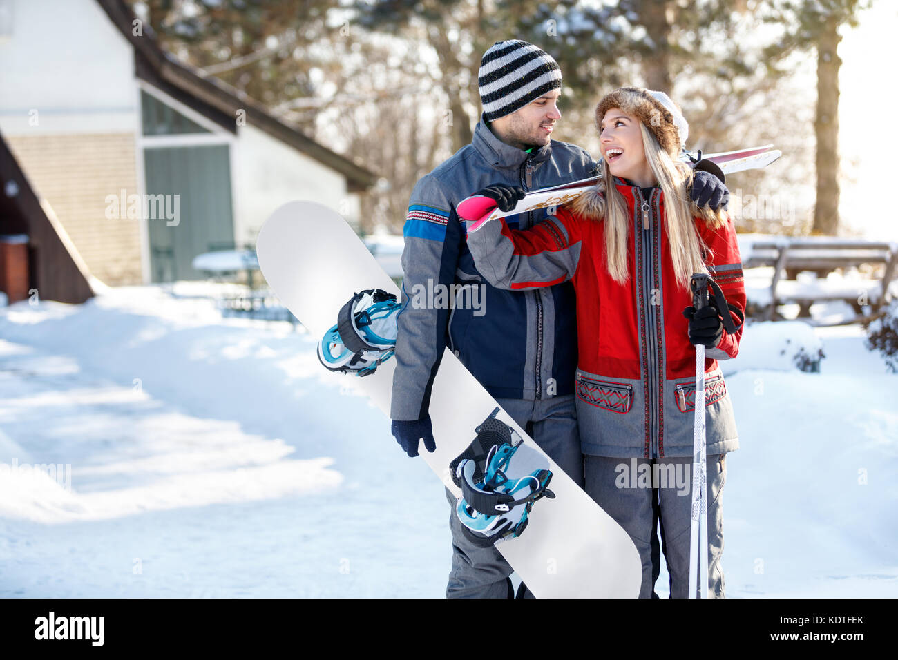 Cheerful skiers couple in love with skis and ski board going to ski ...