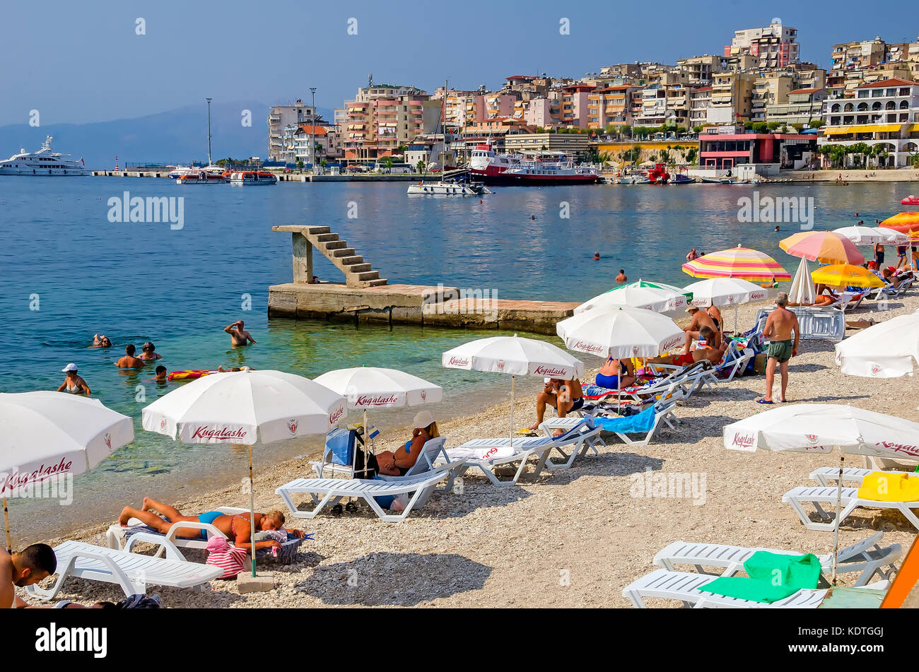 Saranda Beach white umbrellas and city skyline, Sarande, Vlore County ...