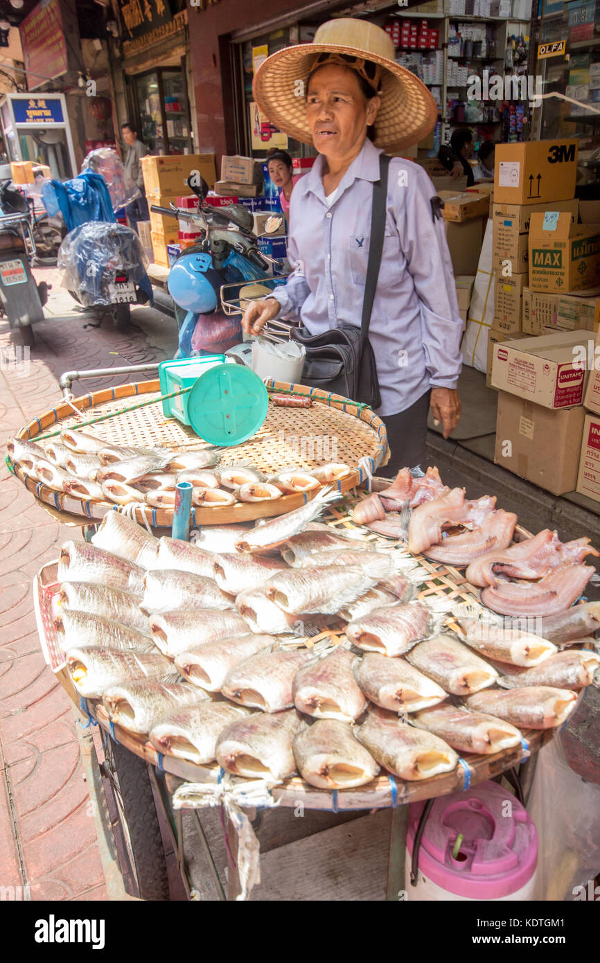 Street food vendor selling dried fish from a mobile food cart ...