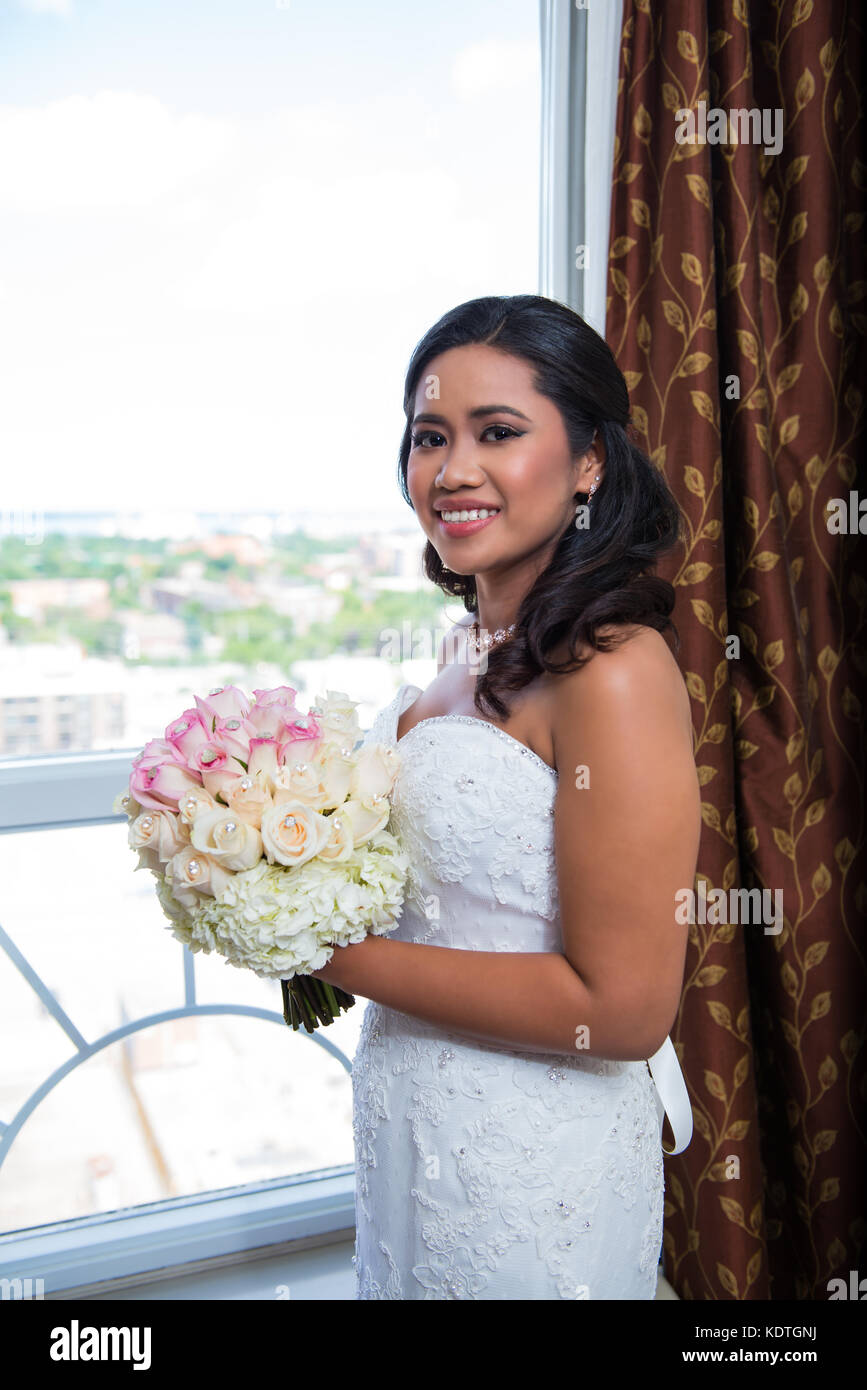 Beautiful smiling bride at window with bouquet Stock Photo - Alamy