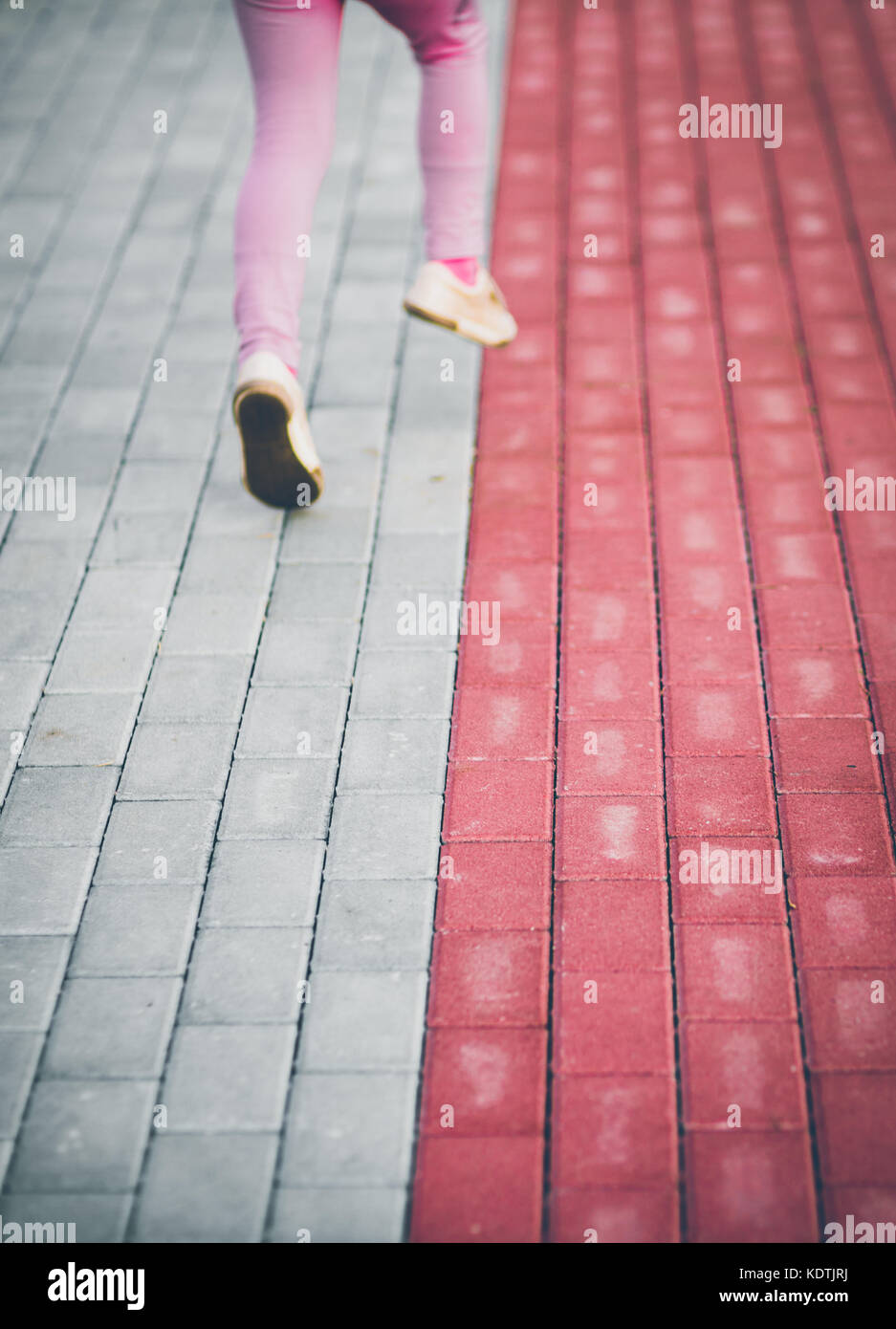 Little girl running on the pavement in town Stock Photo - Alamy