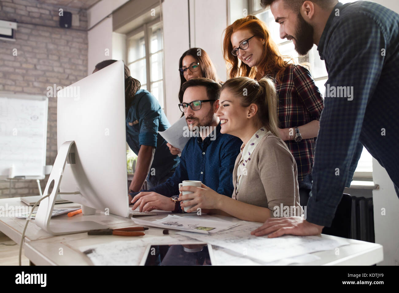 Group of young designers working as team Stock Photo - Alamy