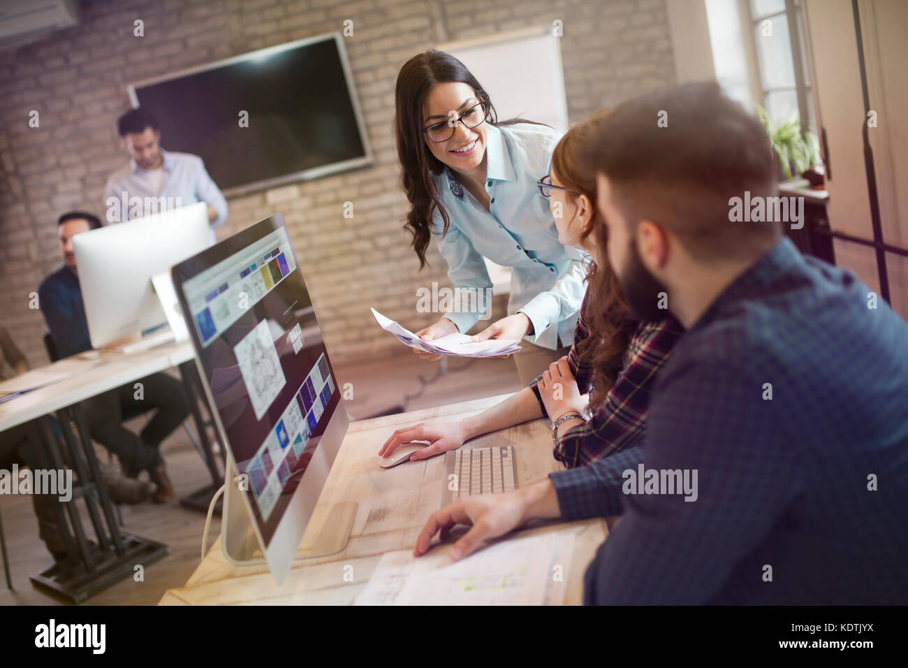 Group of young designers working as team Stock Photo - Alamy