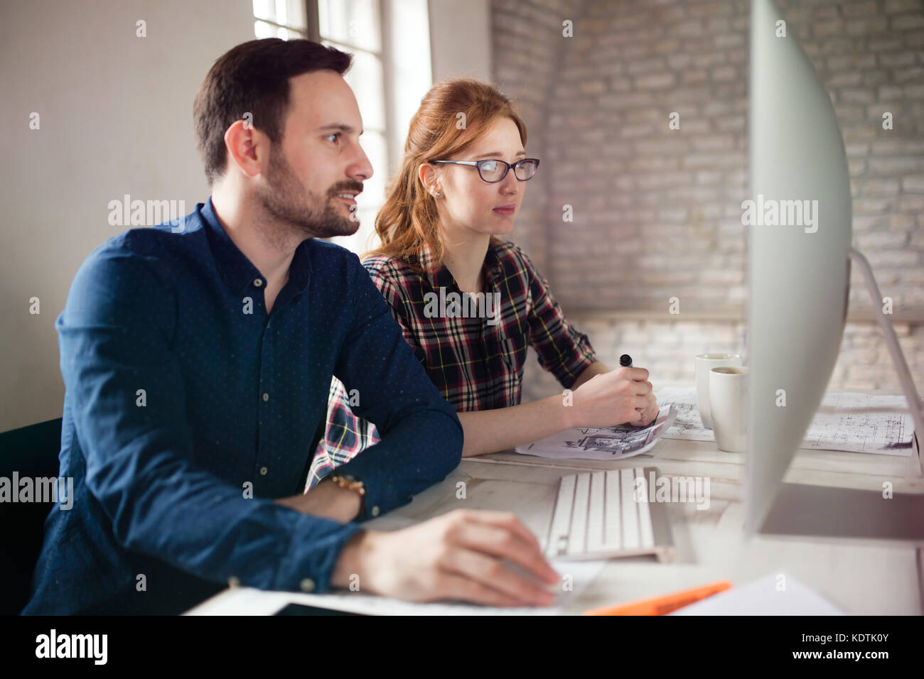 Portrait of young designers working on computer Stock Photo - Alamy