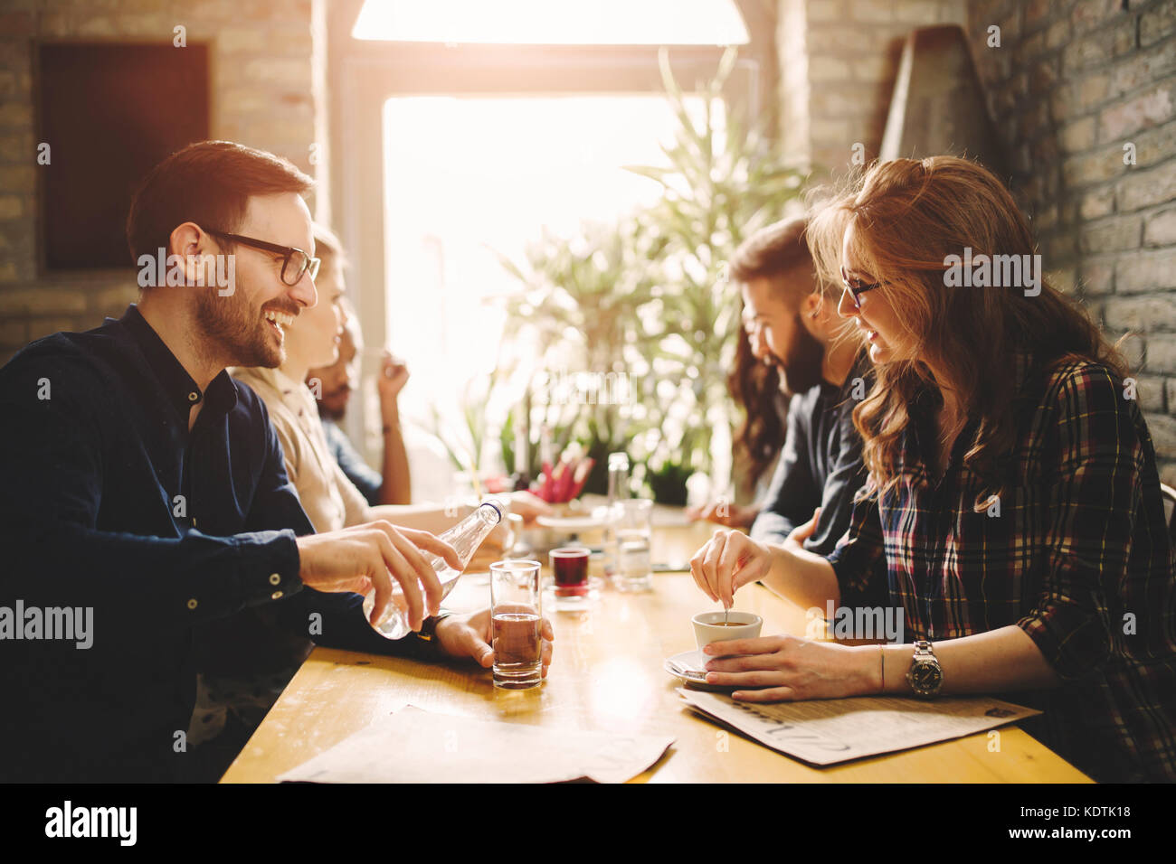 Happy colleagues from work socializing in restaurant Stock Photo - Alamy