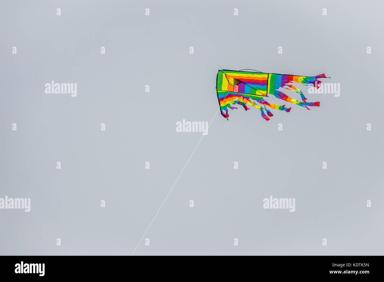 Colourful kite flying high in the sky Stock Photo - Alamy