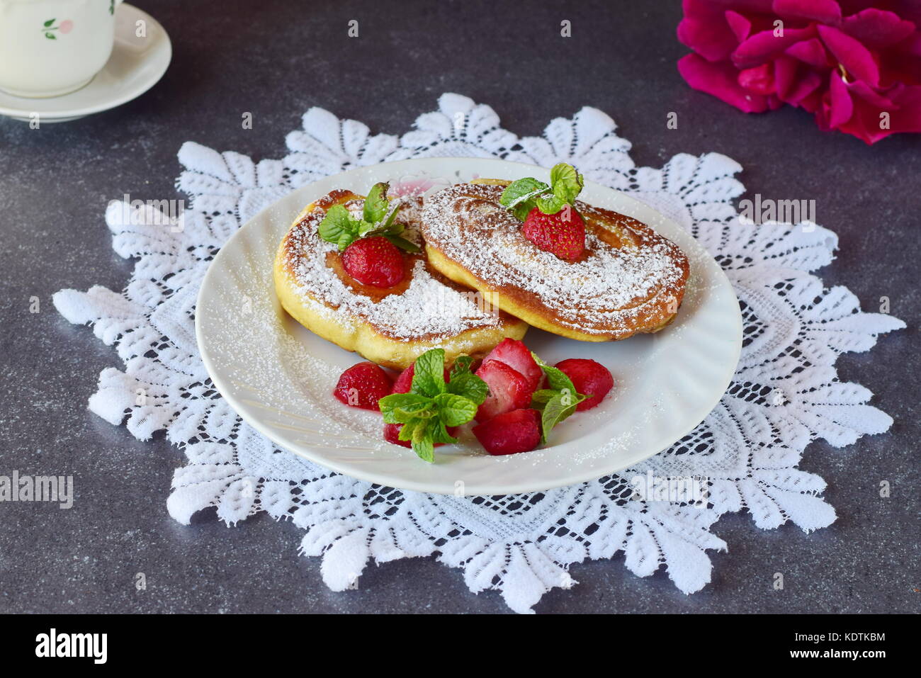 Pancakes with strawberry inside in a white plate on a white lace ...