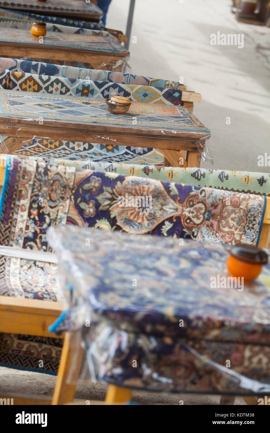 Row of tables covered with traditional carpets in a restaurant in Iran ...