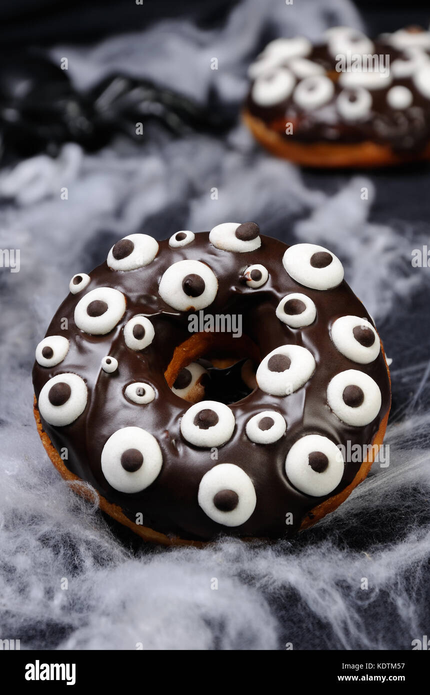 Donuts with chocolate icing decorated googly eyes on Halloween Stock ...
