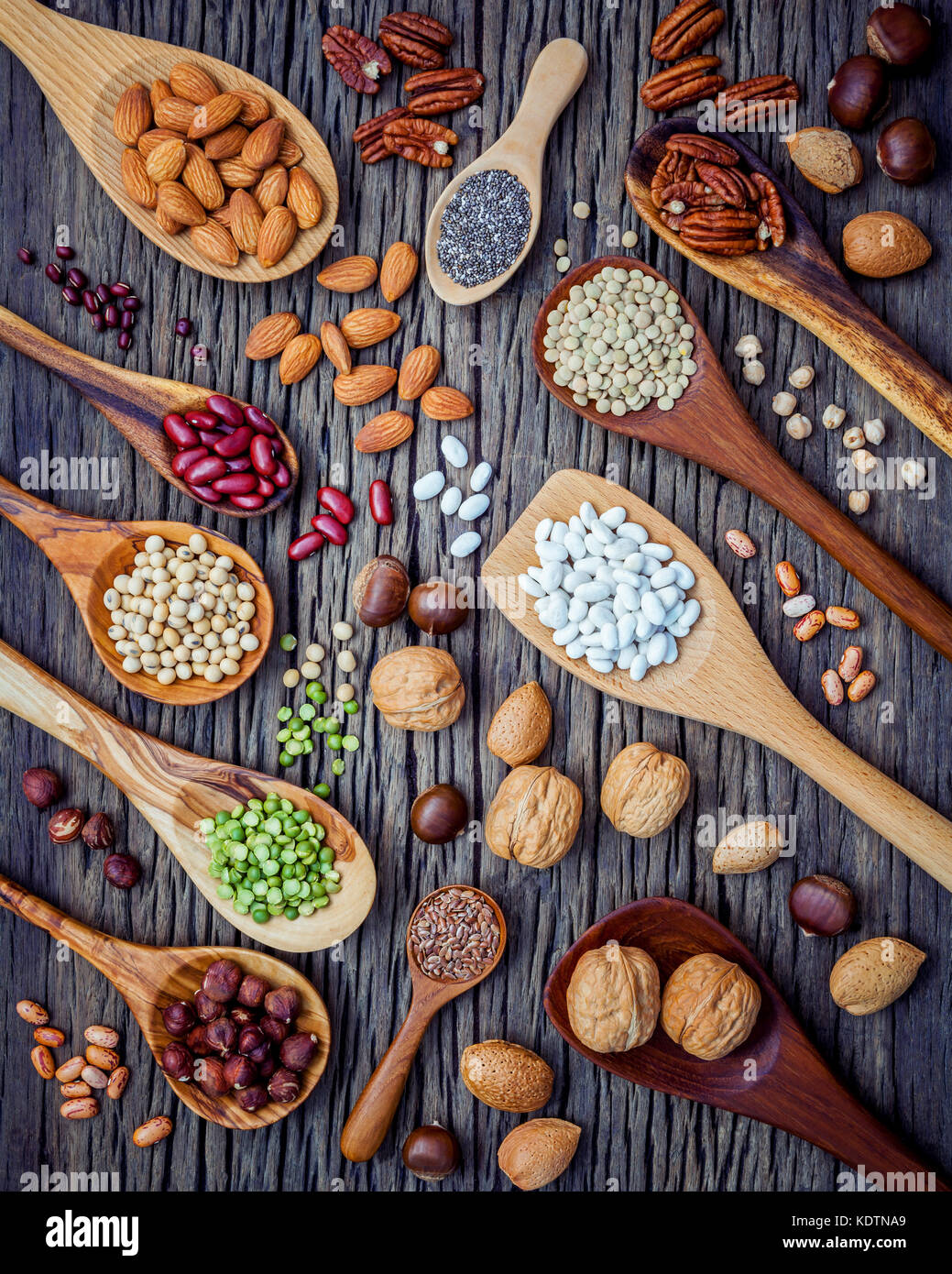 Various legumes and different kinds of nutshells in spoons. Walnuts ...