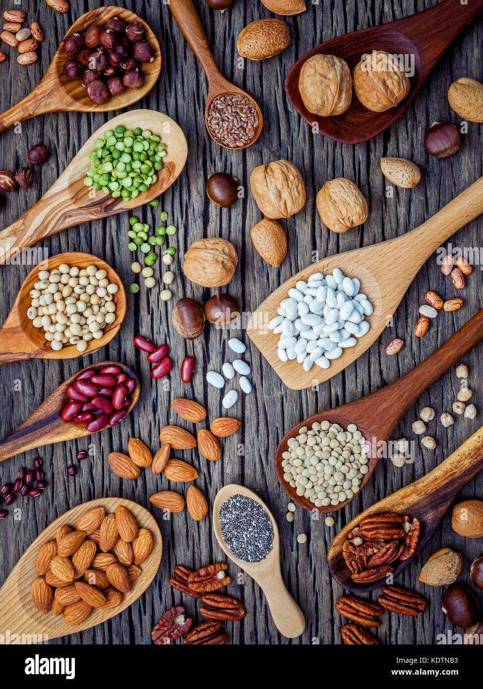 Various legumes and different kinds of nutshells in spoons. Walnuts ...