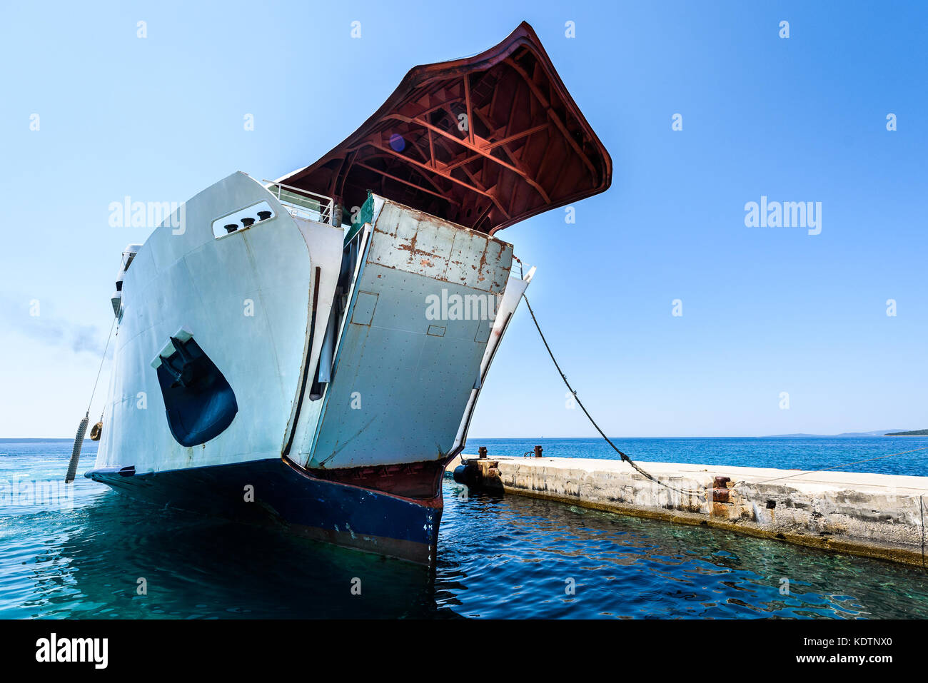 Front loading ferry boat moored with lifted bow at pier. Big ferry boat ...