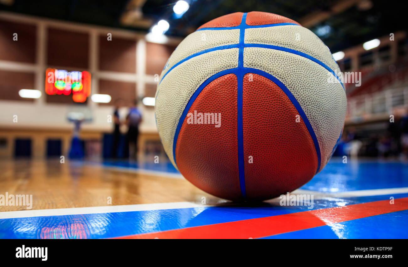 Basketball ball on court floor close up with blurred arena in the ...