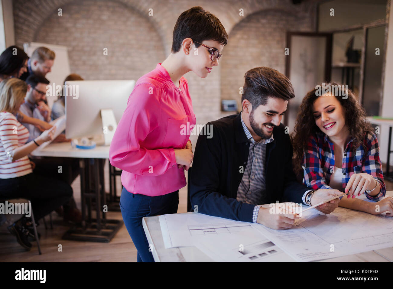 Group of young architects looking at digital tablet Stock Photo - Alamy