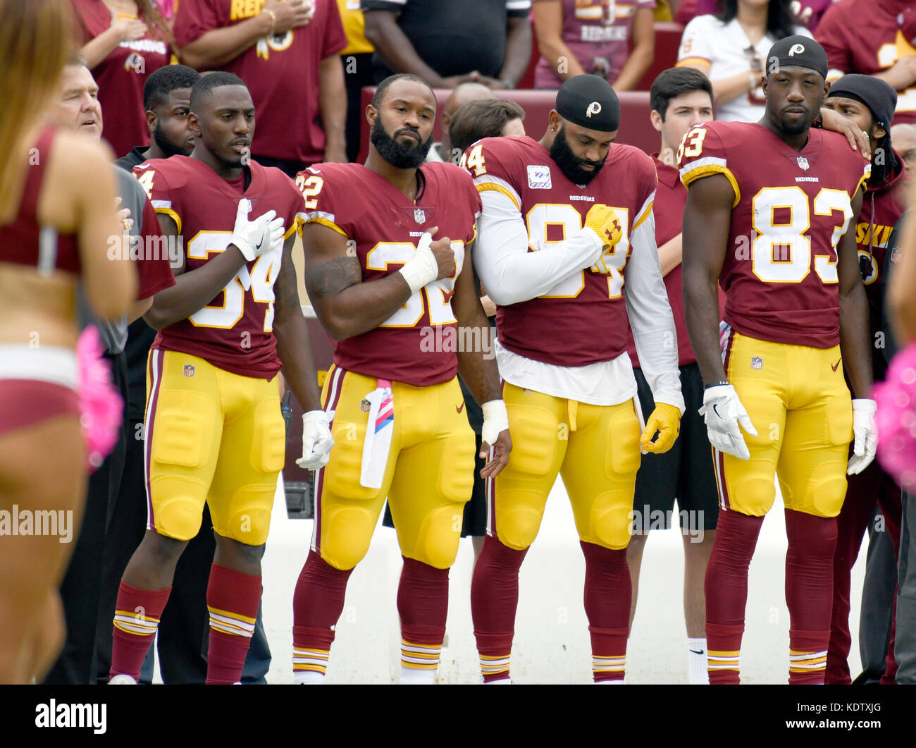 Washington Redskins players stand at attention as the National Anthem ...